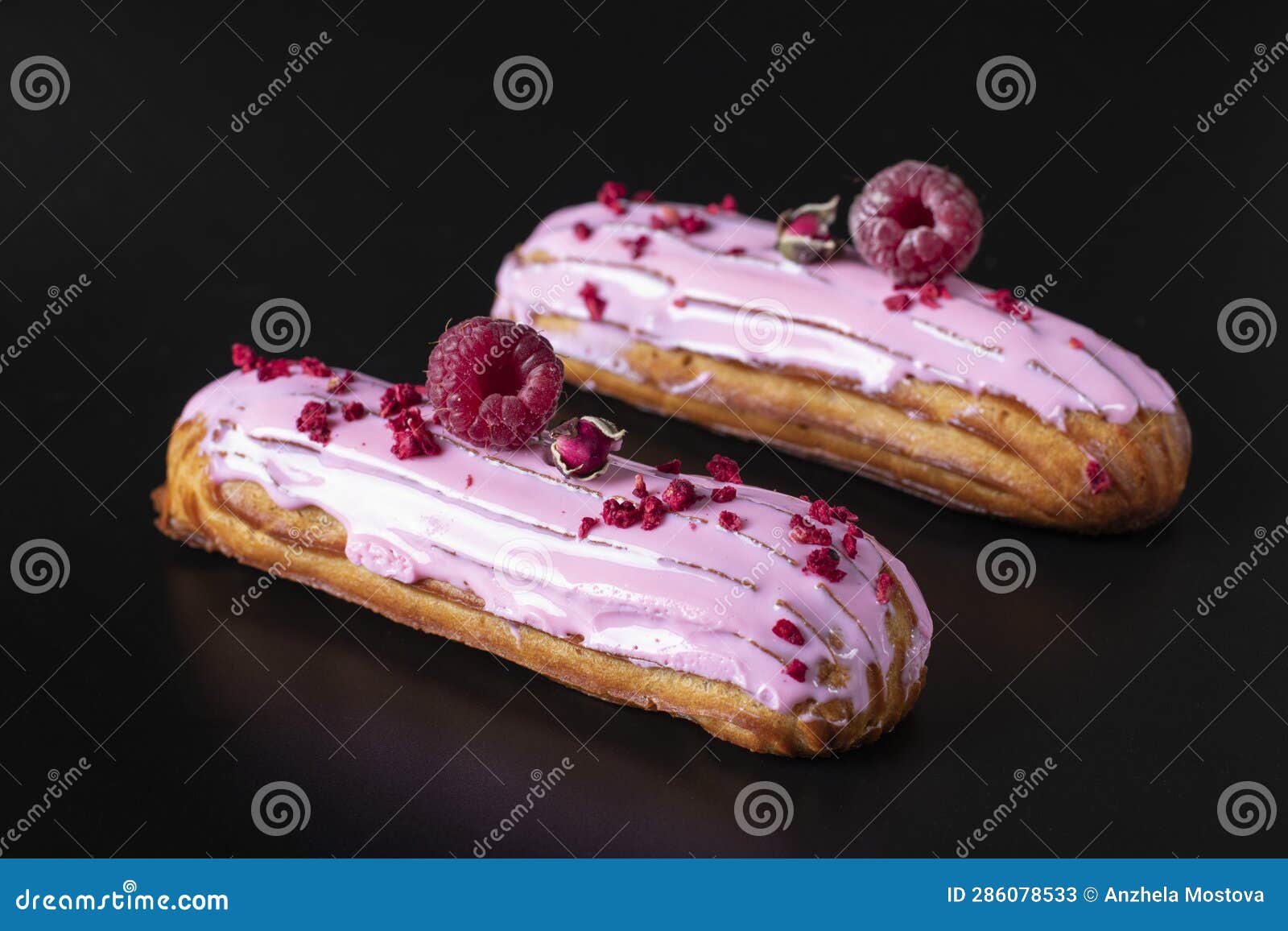 Berry Eclairs Covered with Pink Icing and Decorated with Raspberries on ...