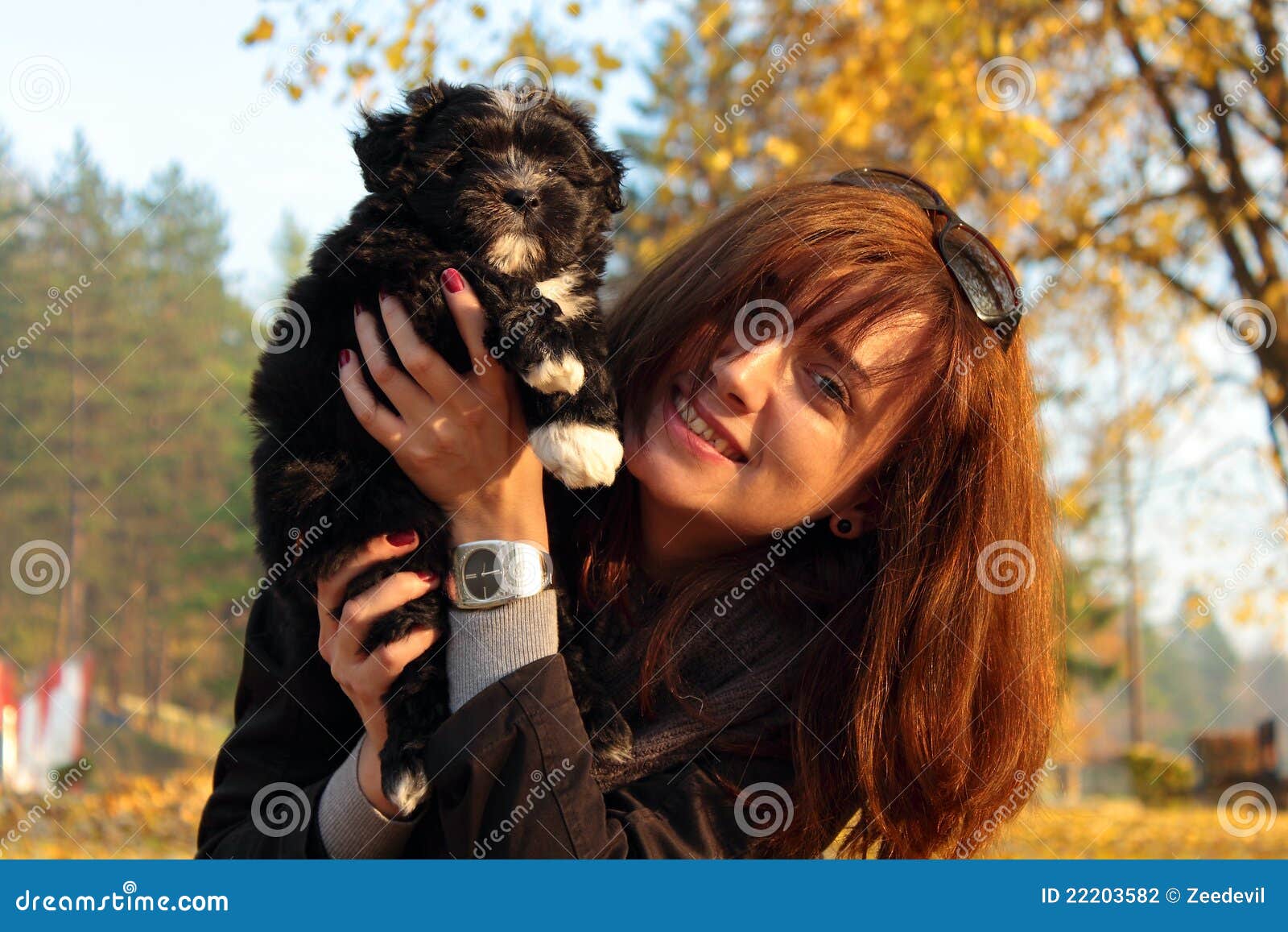 Young Women Smiling while Holding Her Cuddly Puppy in Arms Stock Photo ...