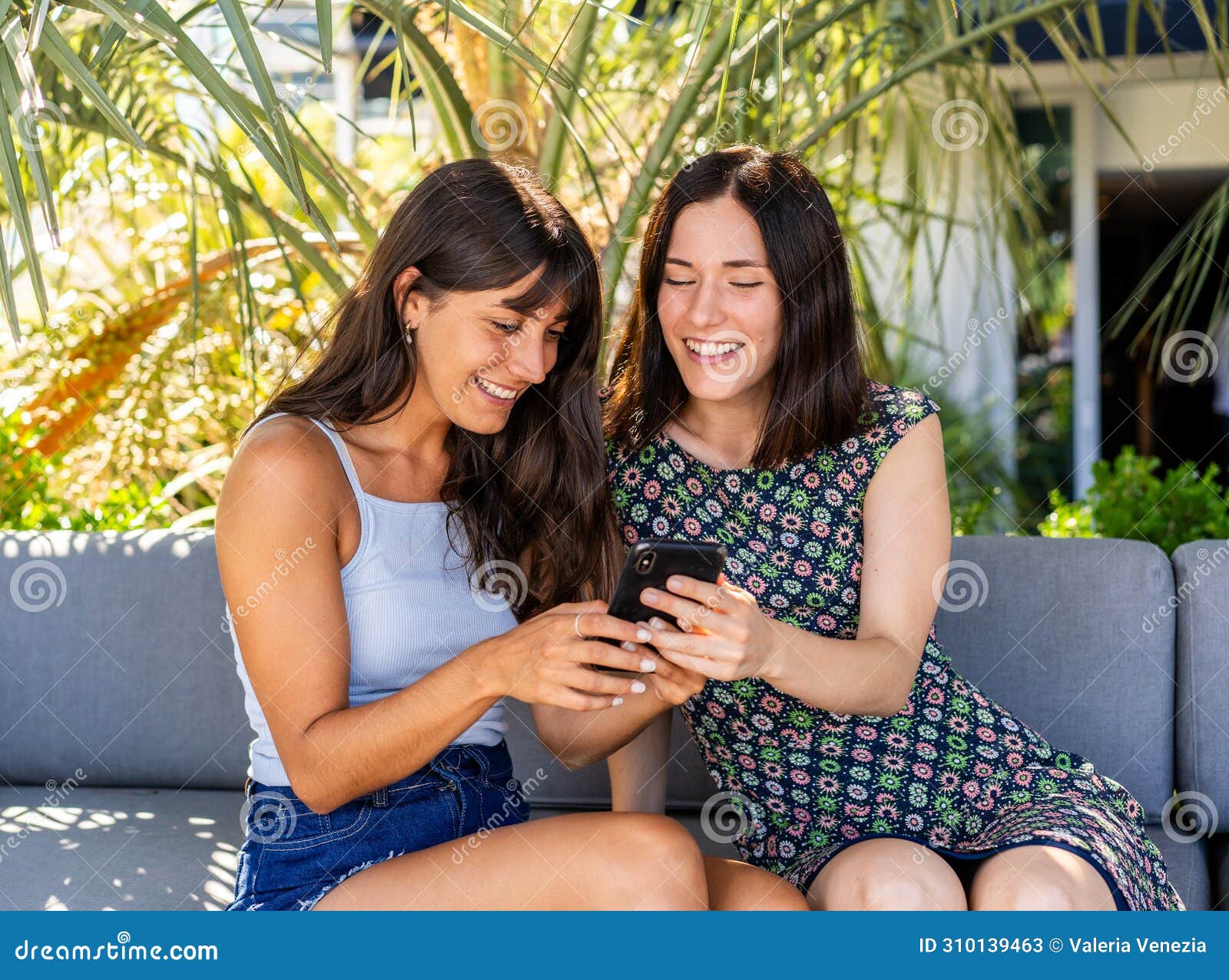 Best friends iusing phone stock image. Image of meeting - 310139463