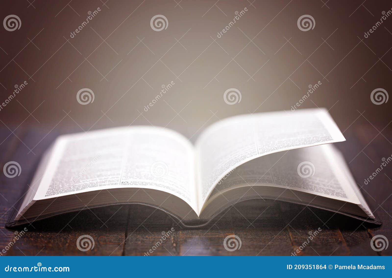 A Bible Open on a Rustic Wooden Table with Pages Blowing Open Stock ...