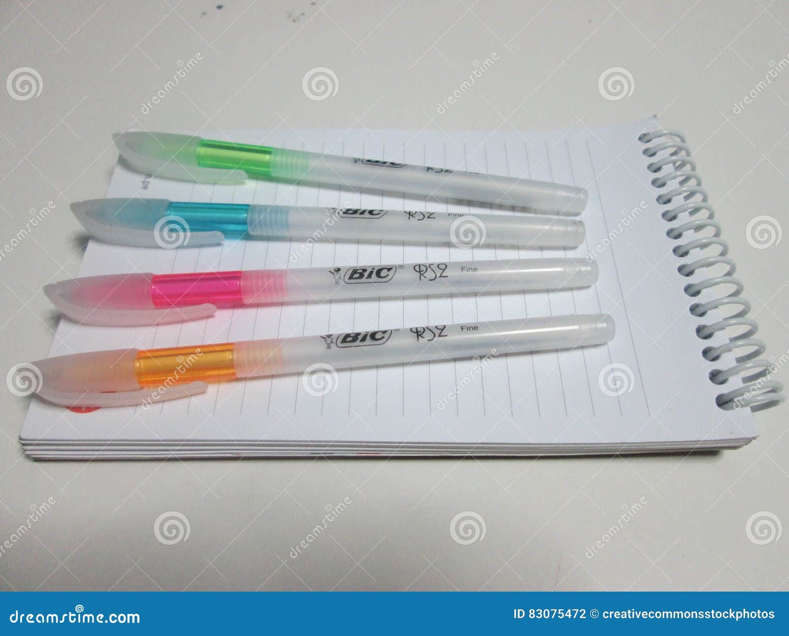 Bic Orange And White Ball Point Pens On Top Of Lined Paper Notebook ...
