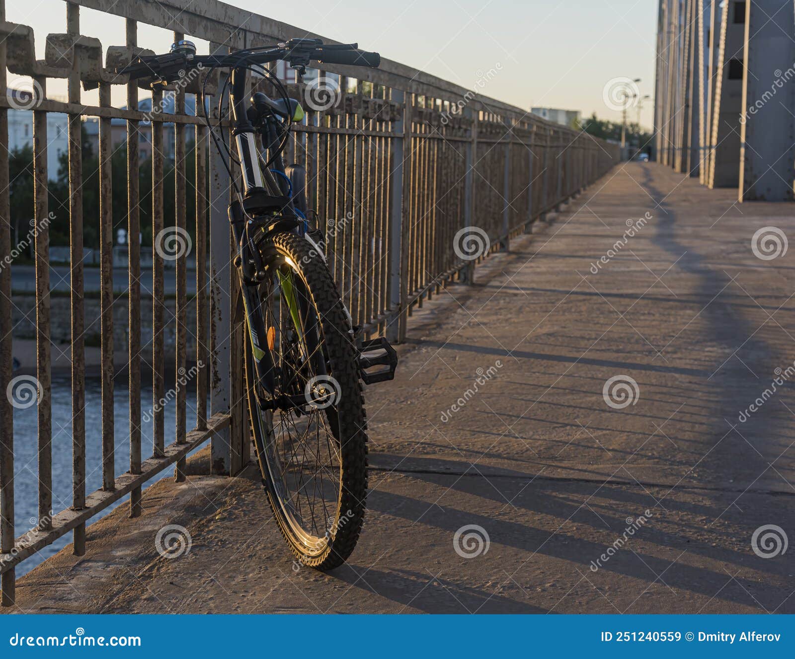 A Bicycle Parked at the Railing of a Bridge Over a Wide, Full-flowing ...