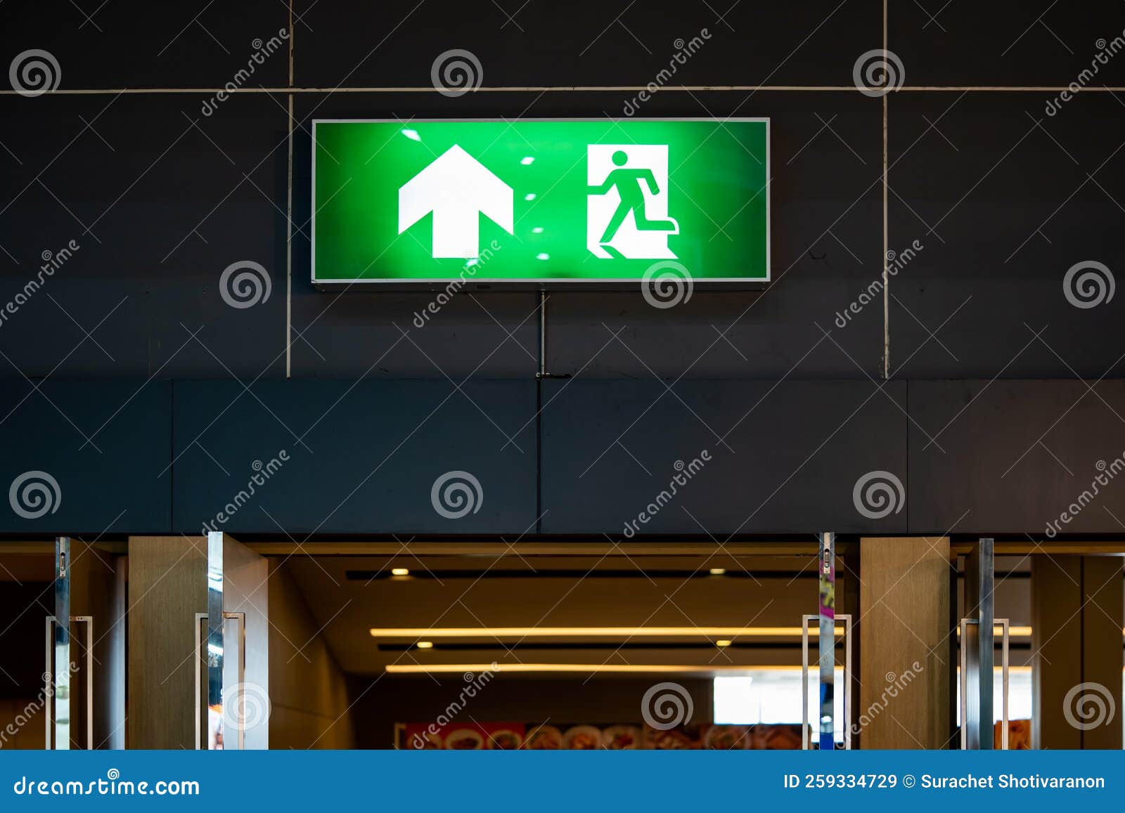 Big Emergency Fire Exit Sign is Placed on the Black Wall Over the Door ...