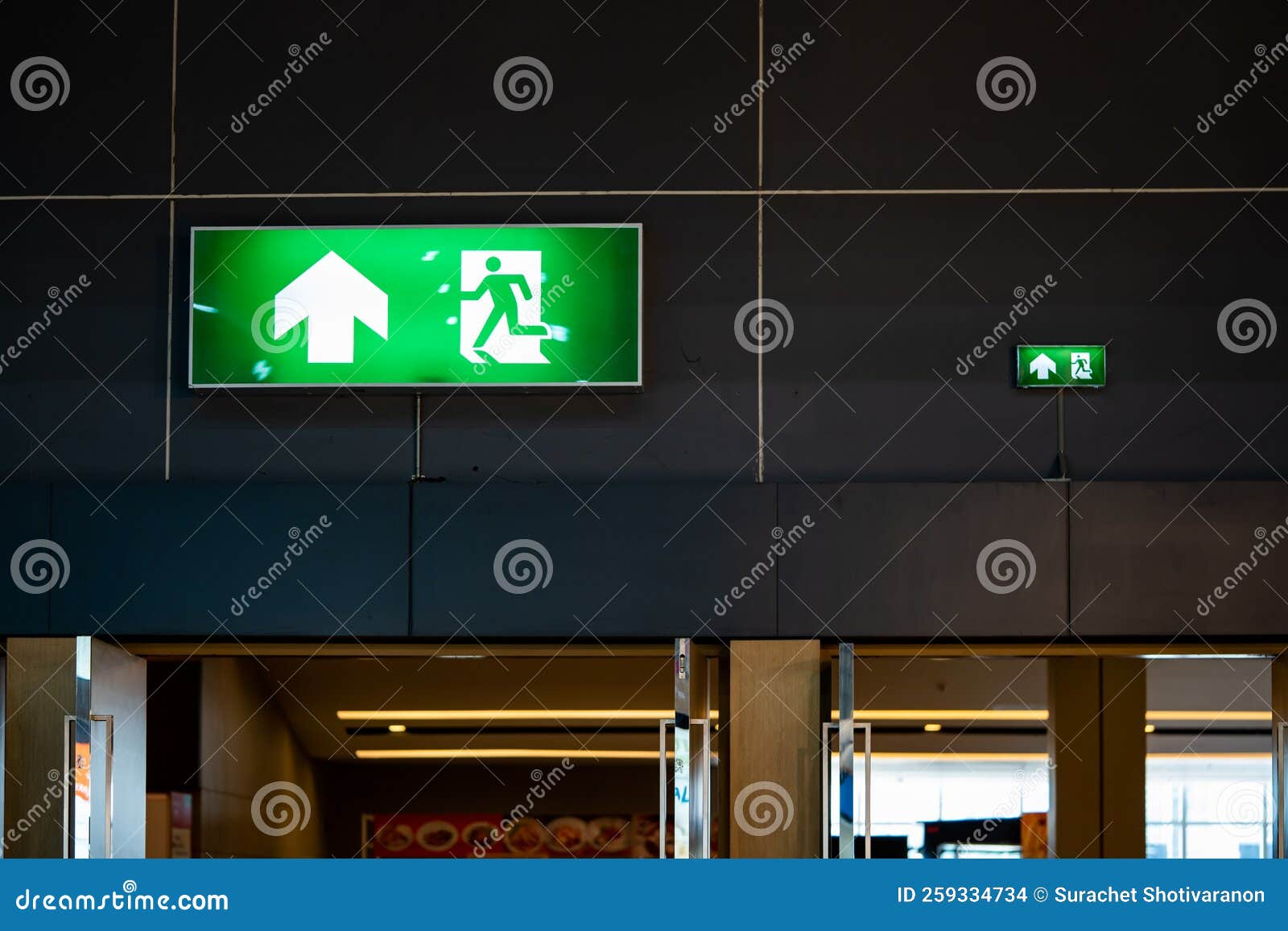 Big Emergency Fire Exit Sign is Placed on the Black Wall Over the Door ...