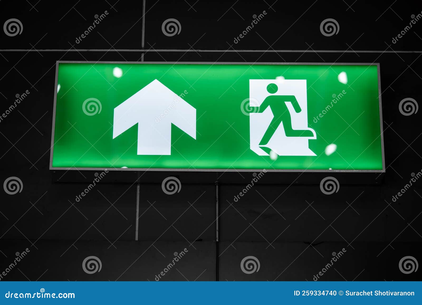 Big Emergency Fire Exit Sign is Placed on the Black Wall Over the Door ...