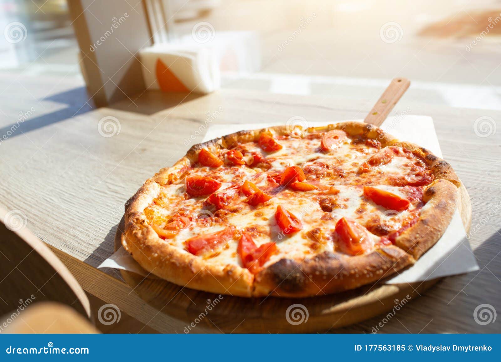 Big Pizza Stands on a Table in a Cafe. Italian Pizza Cut on Pieces ...