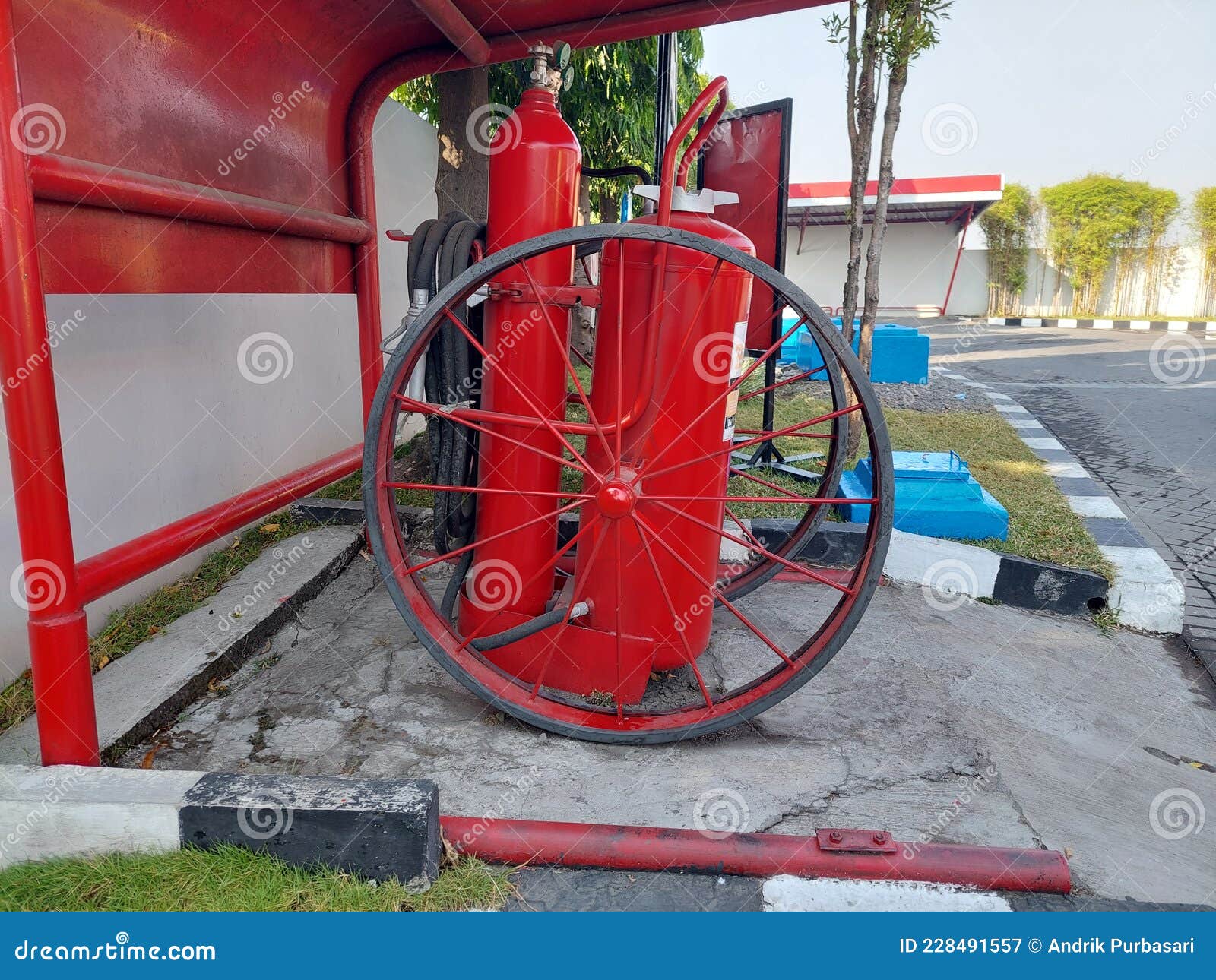 A Big Red Fire Extinguisher with Wheels on the Side Which is on the ...