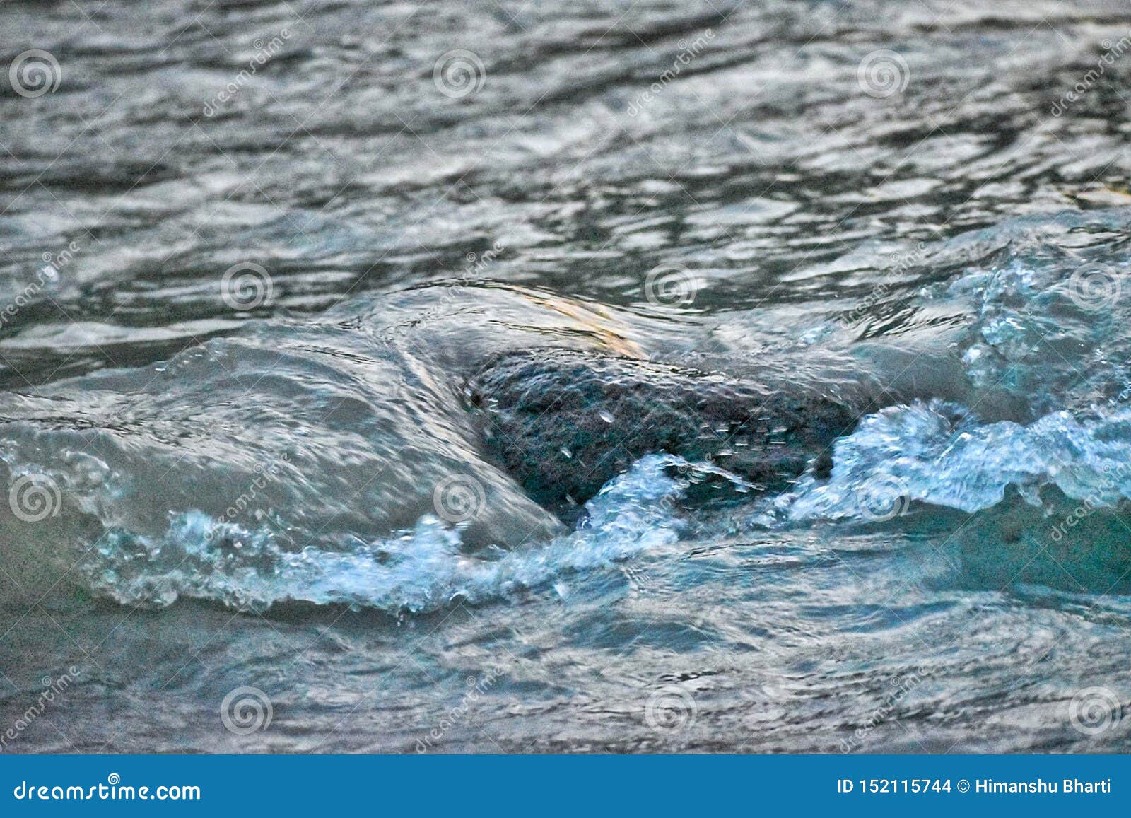 A Big Stone on the Shore of River Getting Hit by the Water Wave Stock ...