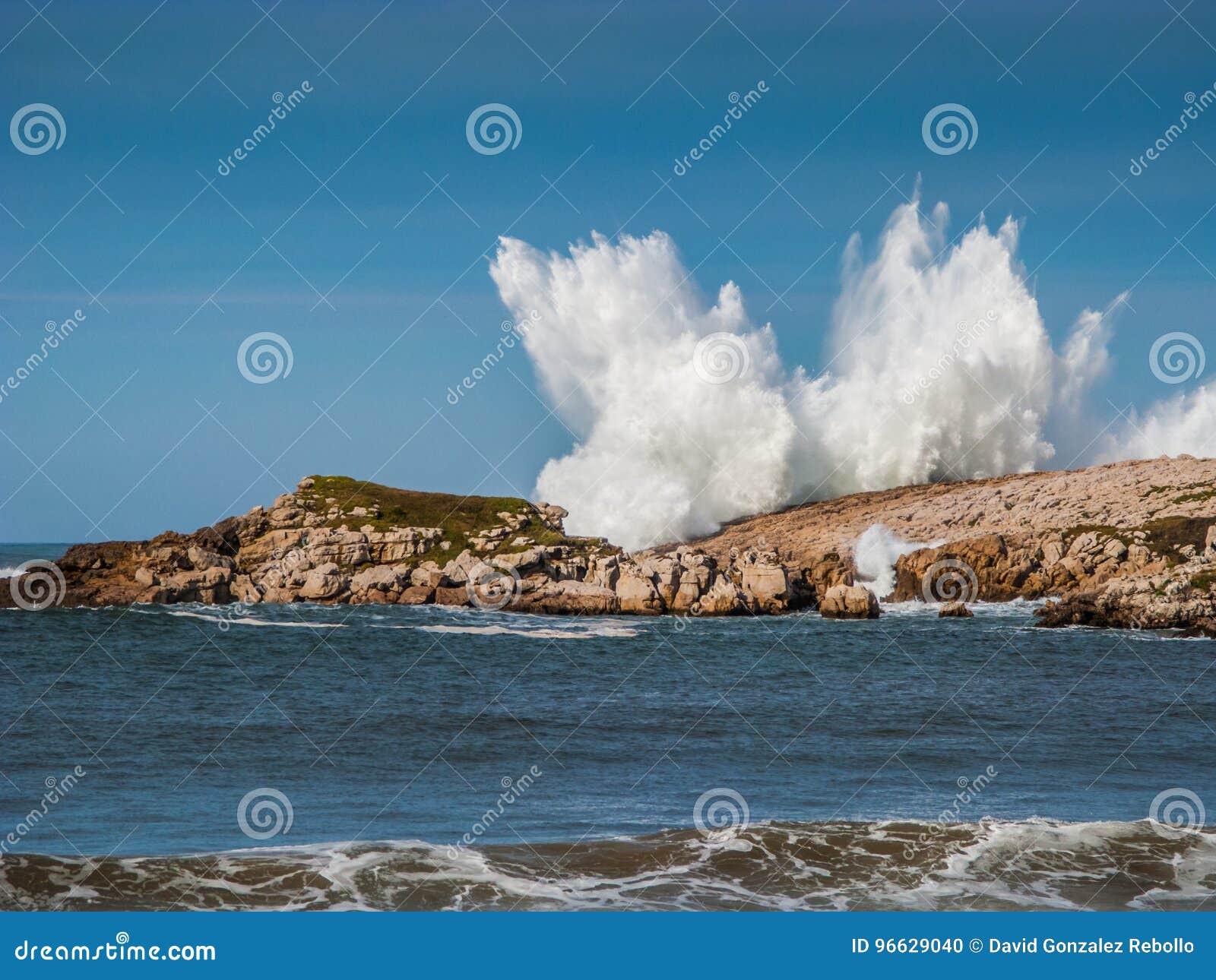 Big wave over the rocks stock photo. Image of miengo - 96629040