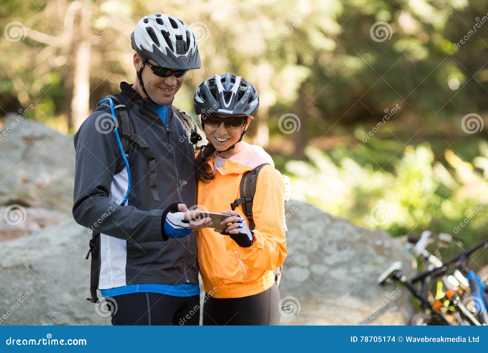 Biker Couple Using Mobile Phone in Forest Stock Photo - Image of ...
