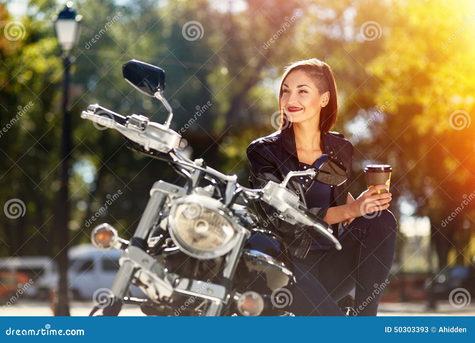 Biker Girl in a Leather Jacket on a Motorcycle Drinking Coffee Stock ...