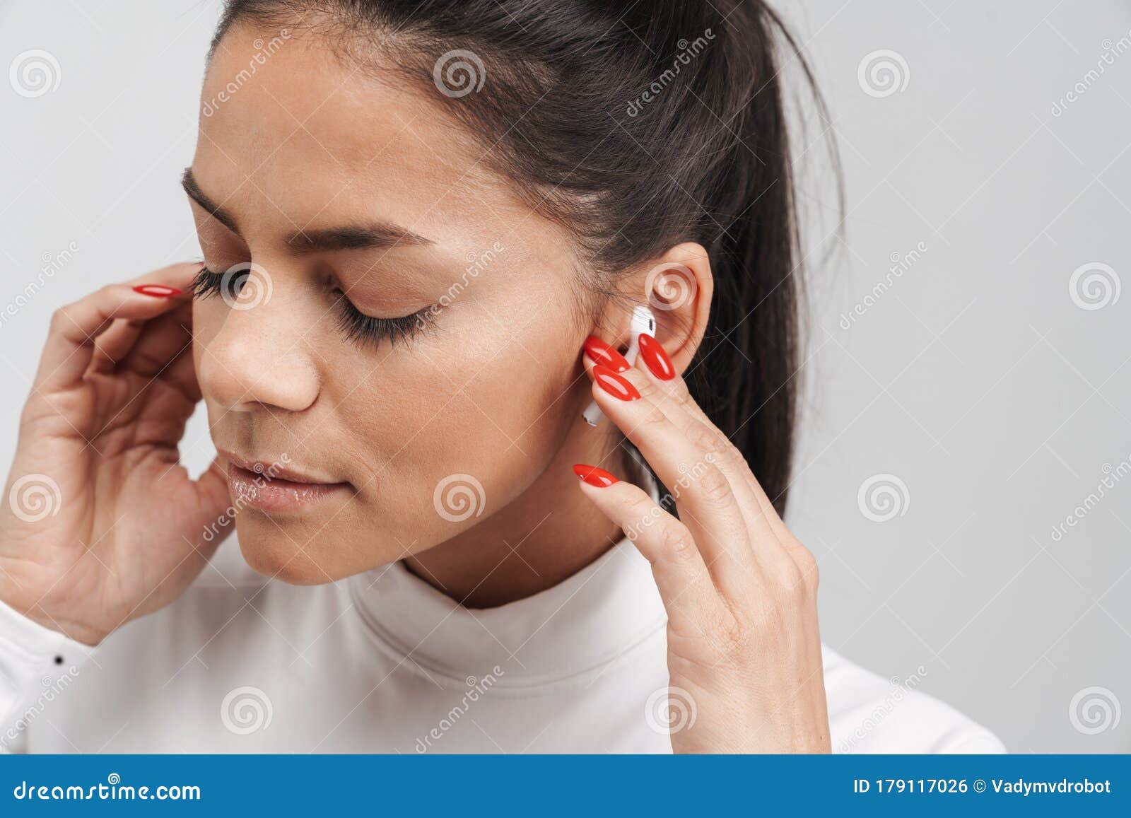 Bild Der Brunette Frau in Der Sportbekleidung, Die Auf Die Earpods ... Bild Der Brunette Frau in Der Sportbekleidung, Die Auf Die Earpods ...