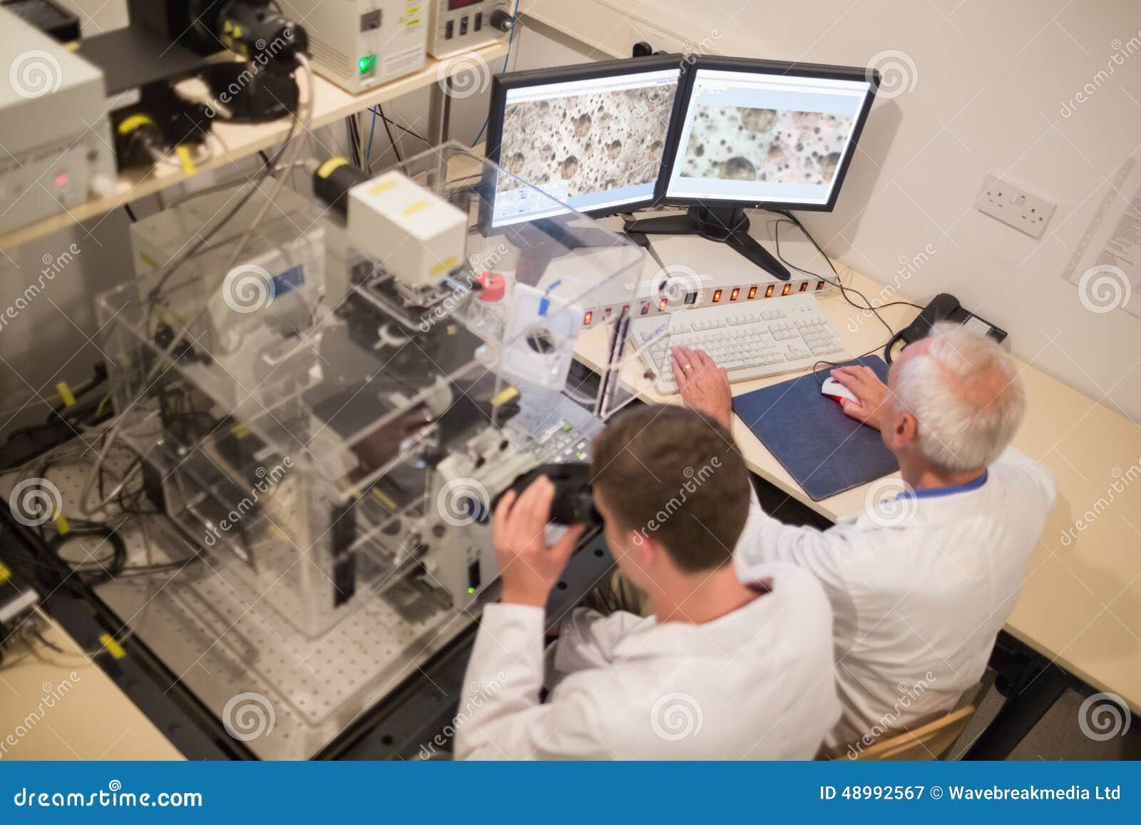 Biochemist and Student Looking at Microscopic Images on Computer Stock ...