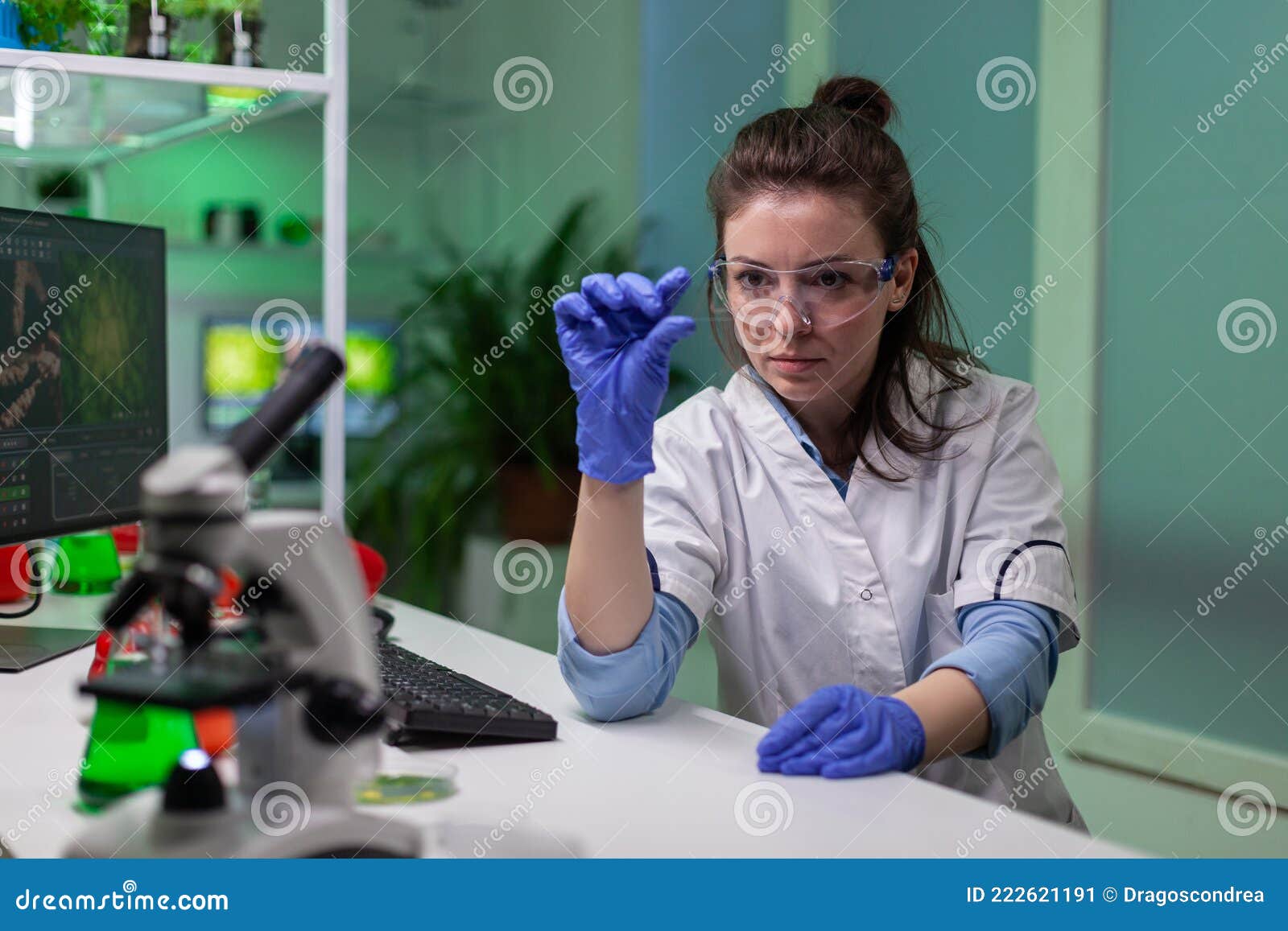 Biochemistry Scientist Analyzing Green Liquid Sample Using Microscope ...