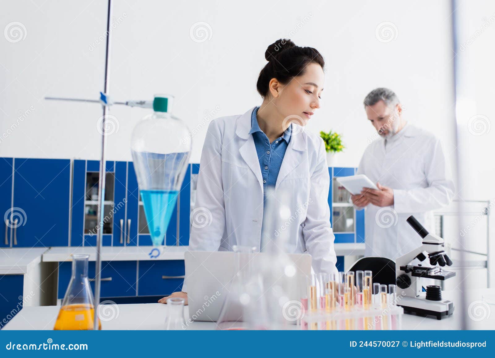 Bioengineer Looking at Microscope while Standing Stock Image - Image of ...