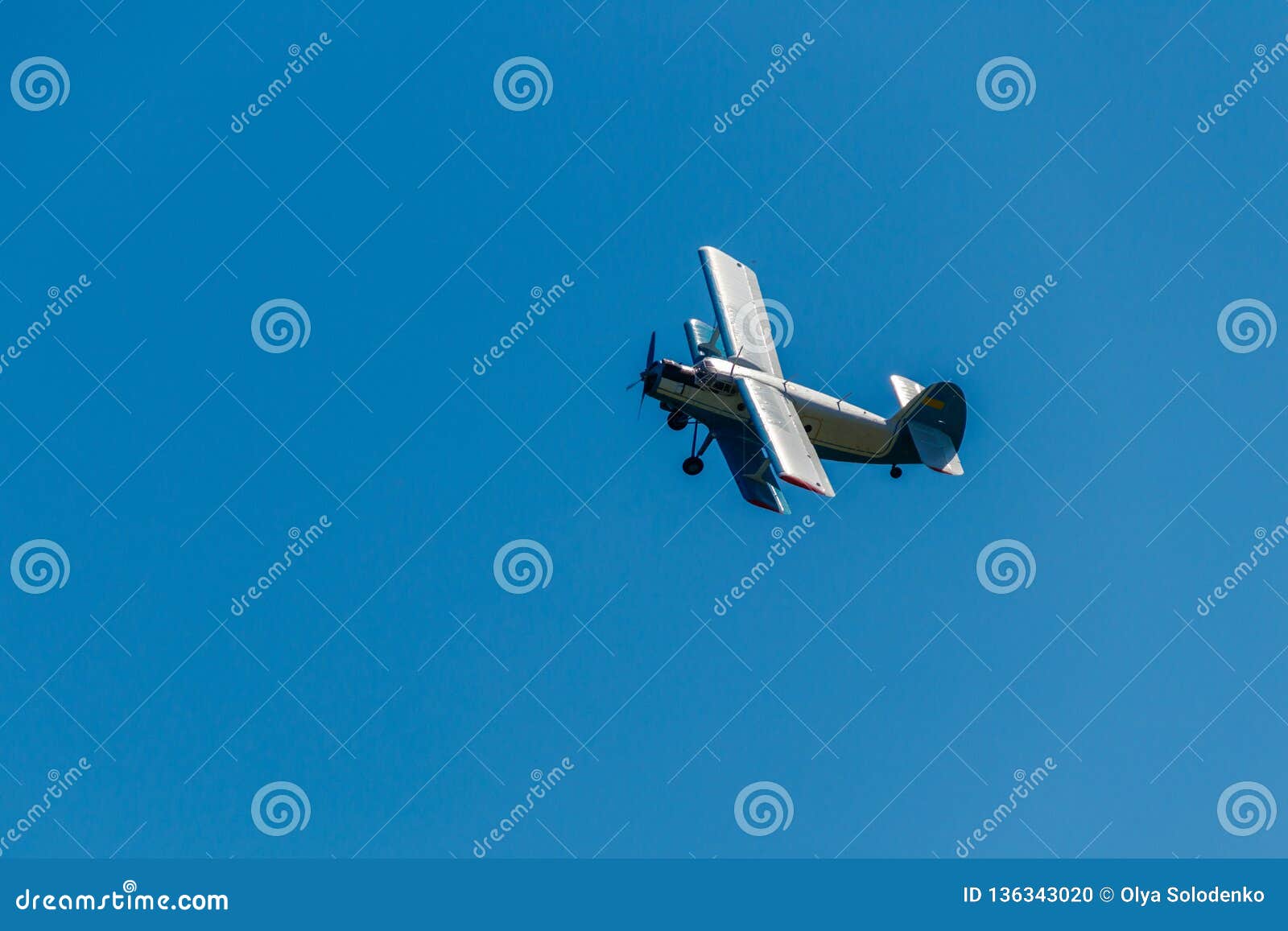 Biplane flying in blue sky stock photo. Image of height - 136343020