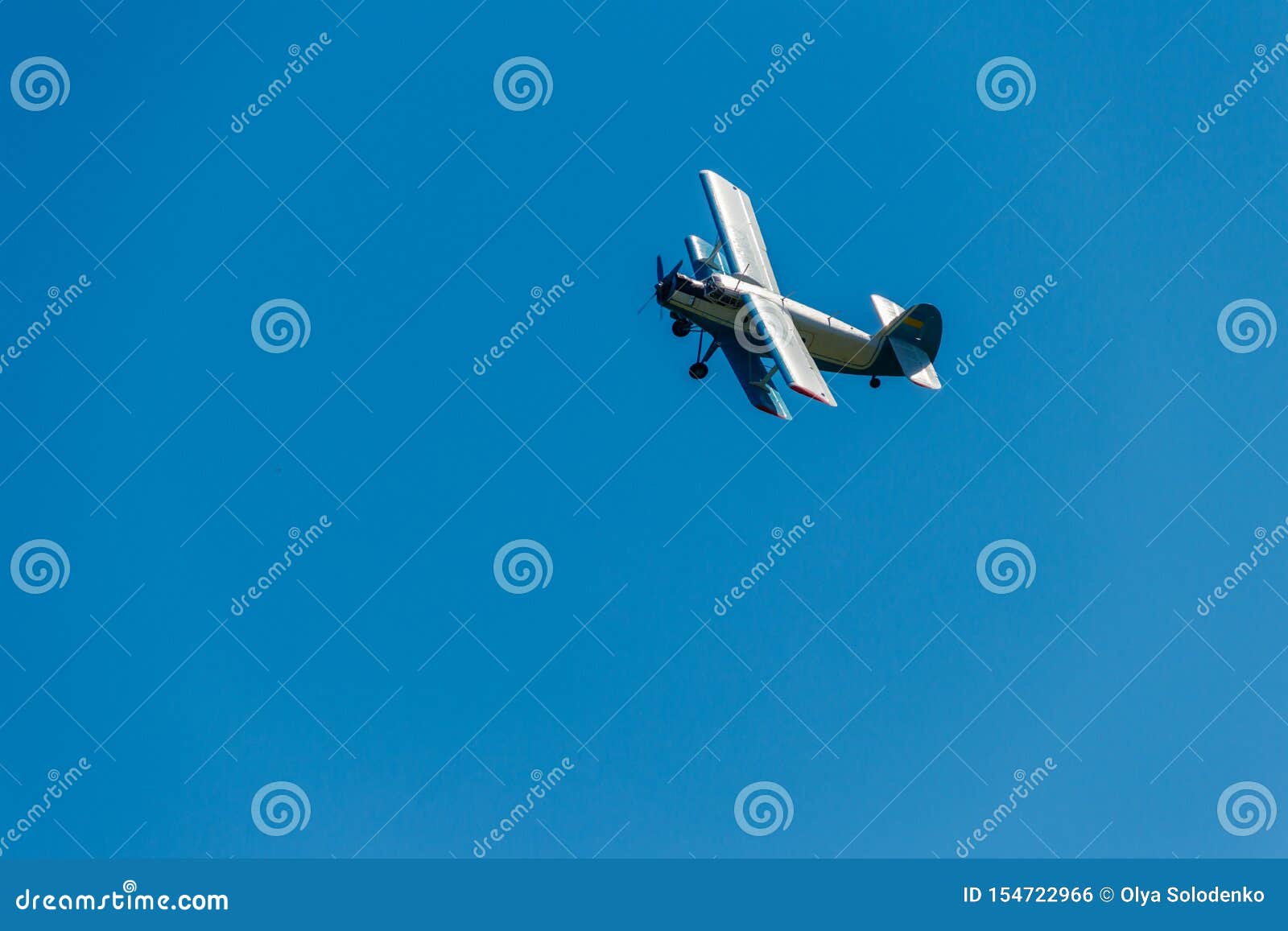 Biplane flying in blue sky stock photo. Image of airplane - 154722966