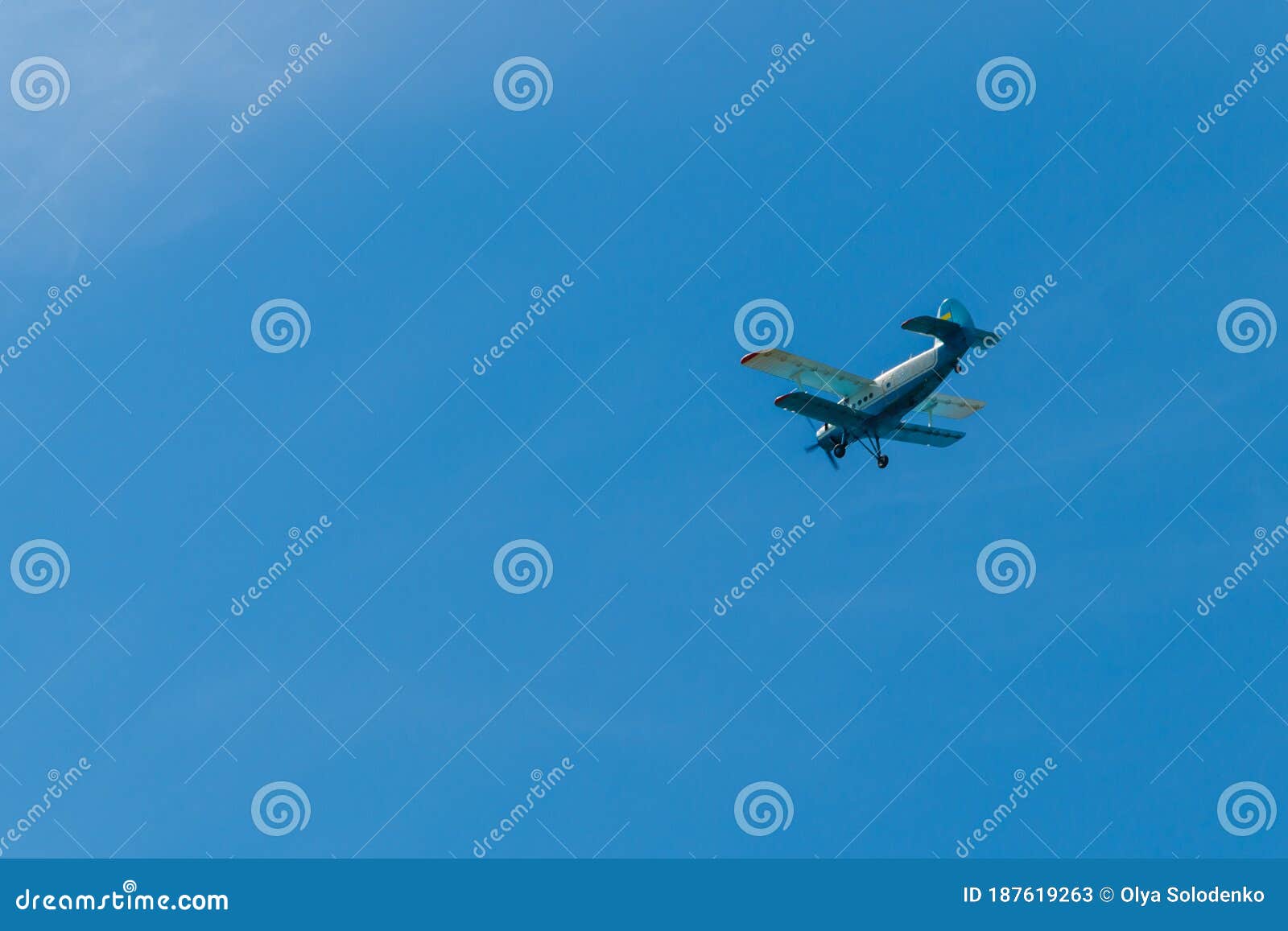 Biplane flying in blue sky stock image. Image of blue - 187619263