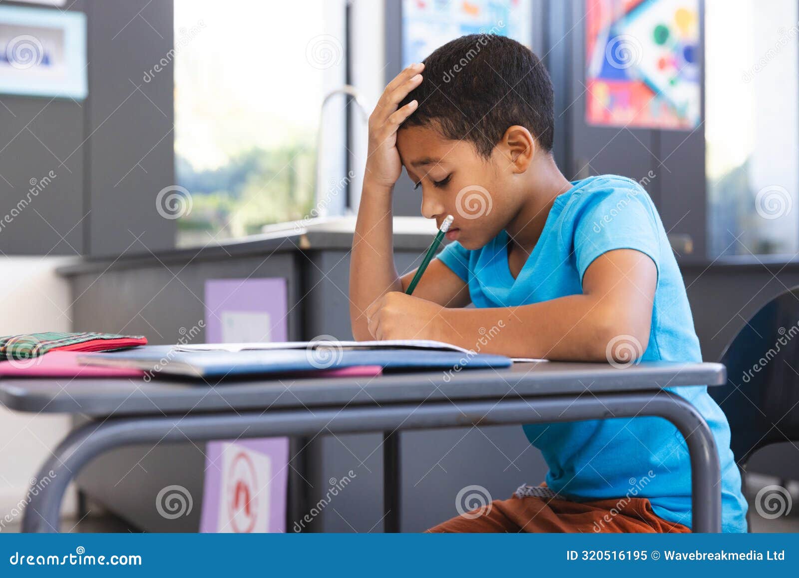 Biracial Boy Focused on Schoolwork in the Classroom at School Stock ...