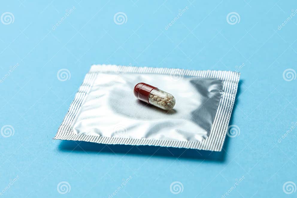 Birth Control Pills And Condom In Package On Blue The Concept Of