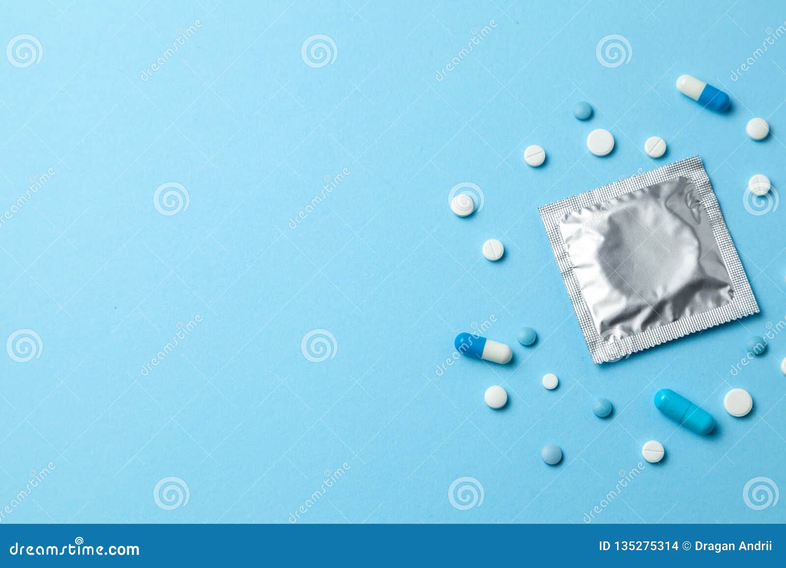 Birth Control Pills And Condom In Package On Blue Concept Of Choosing