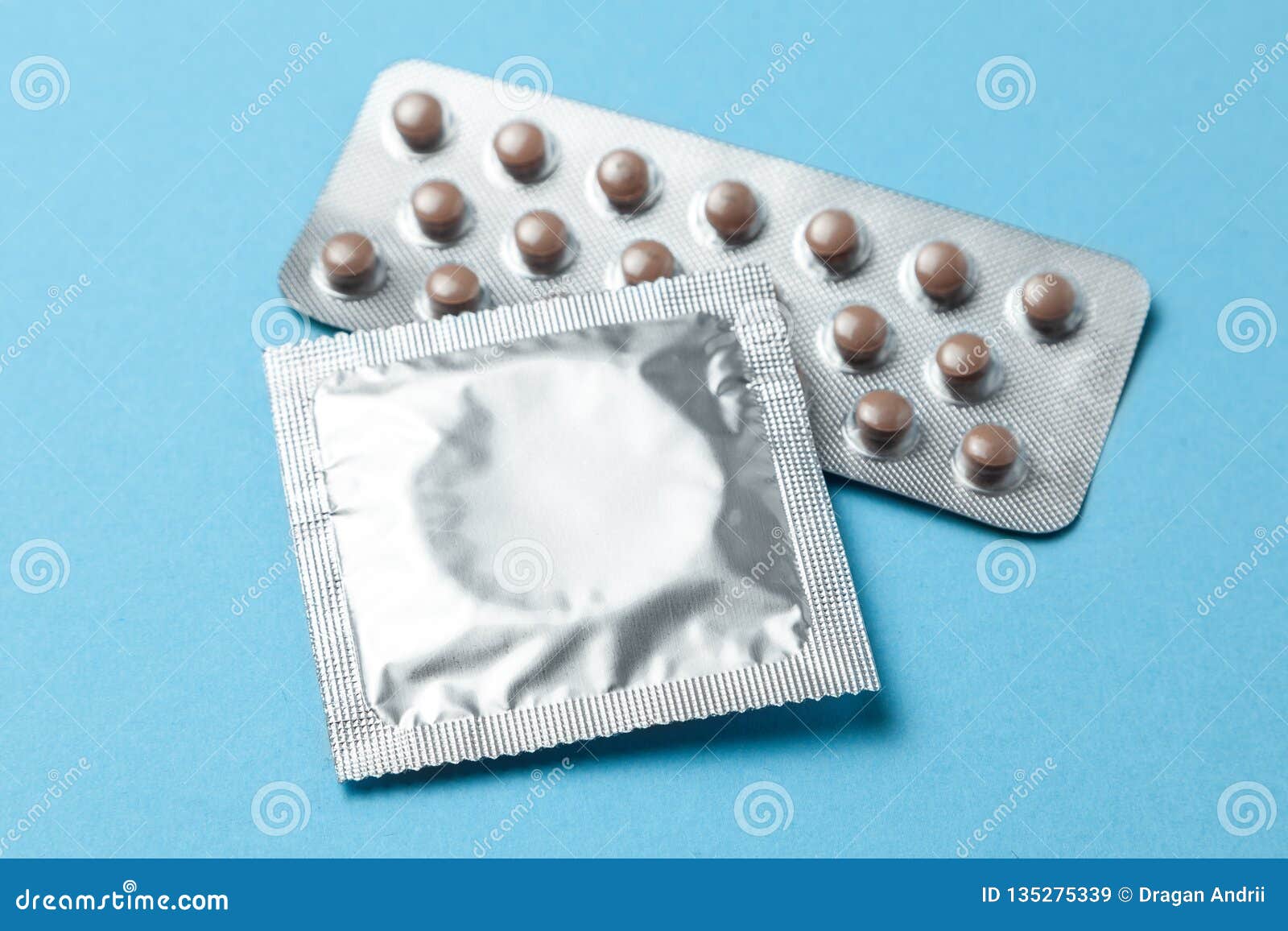 Birth Control Pills And Condom In Package On Blue The Concept Of