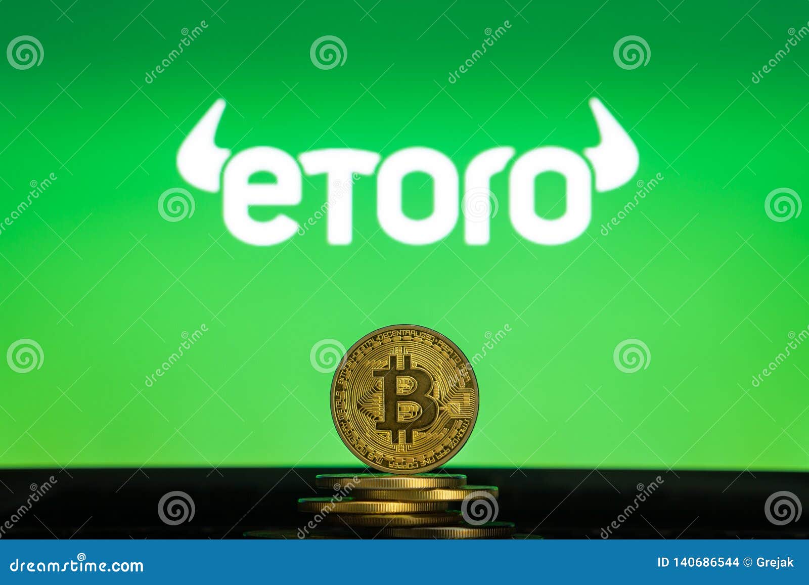 EToro Logo on a Computer Screen with a Stack of Bitcoin Cryptocurency ...