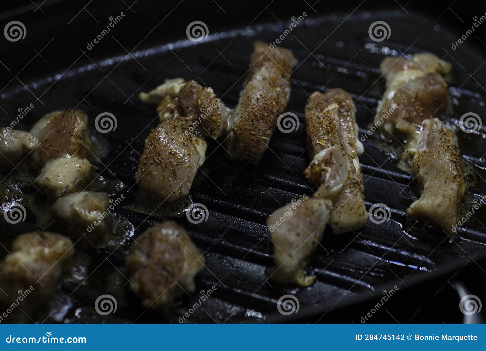 Bite Sized Pieces of Chicken Grilling on a Griddle. Stock Photo - Image ...