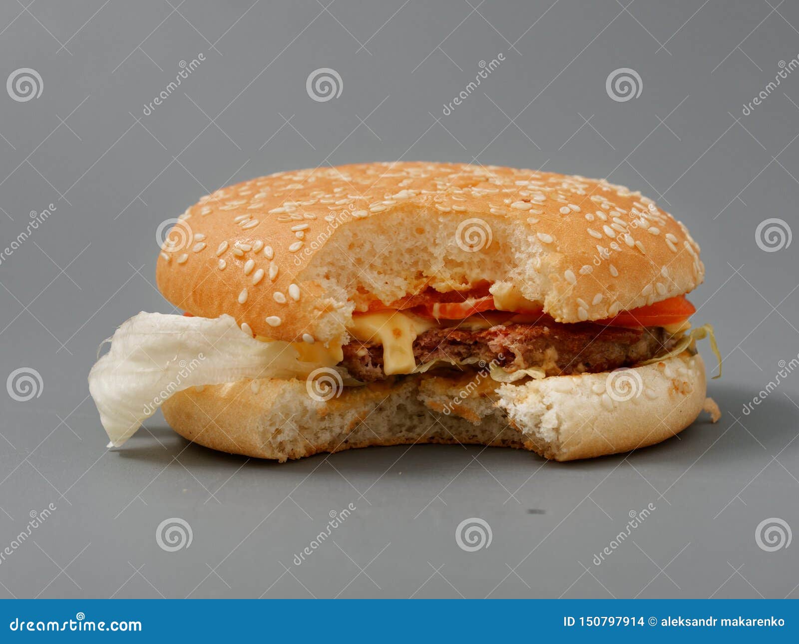 Bitten Big Burger with Cutlet Cheese and Tomato on a Gray Background ...