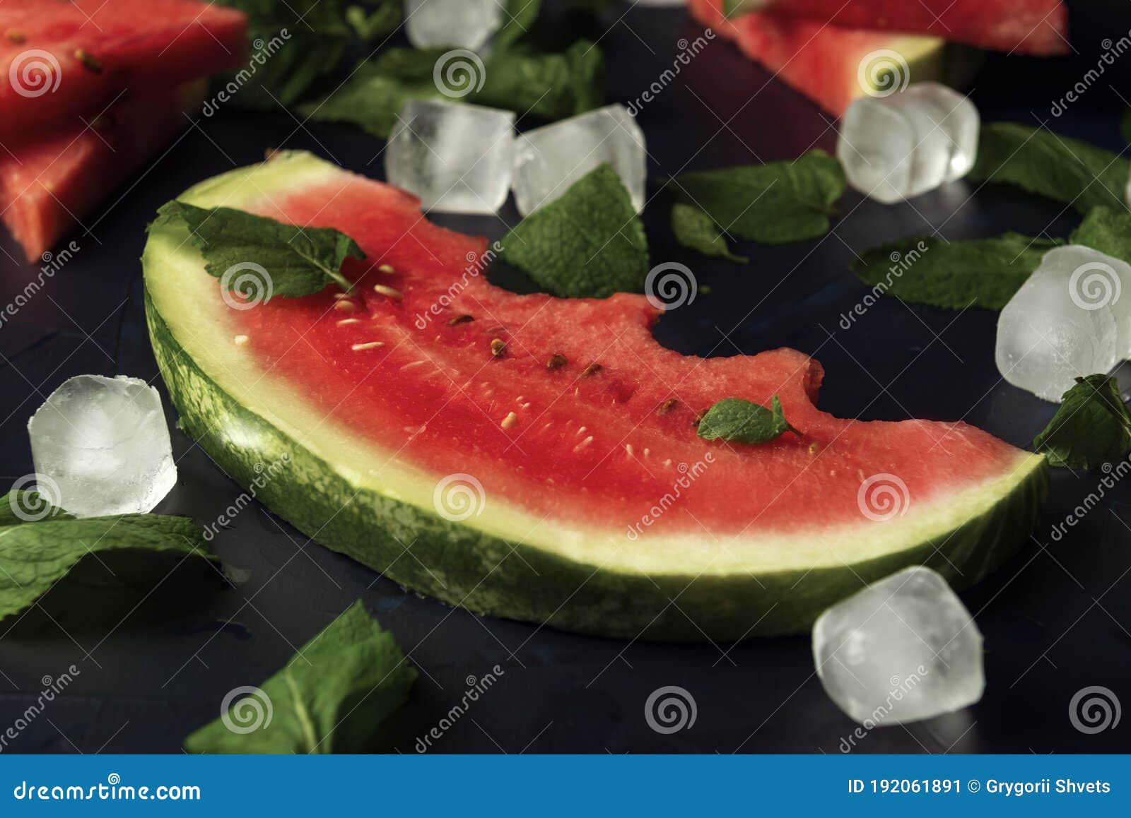 Bitten Slice of Watermelon with Mint Leaves and Ice Cubes on Black ...