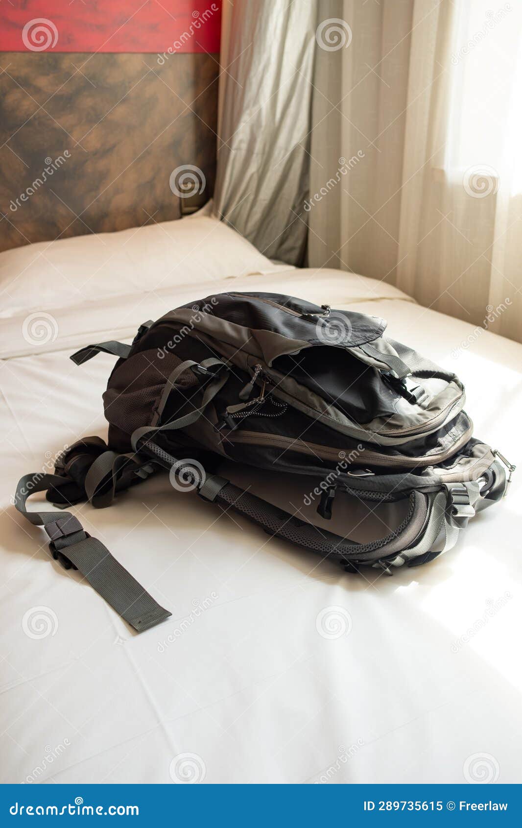 A Black Backpack on the Bed of a Hotel Room Vertical Composition Stock ...
