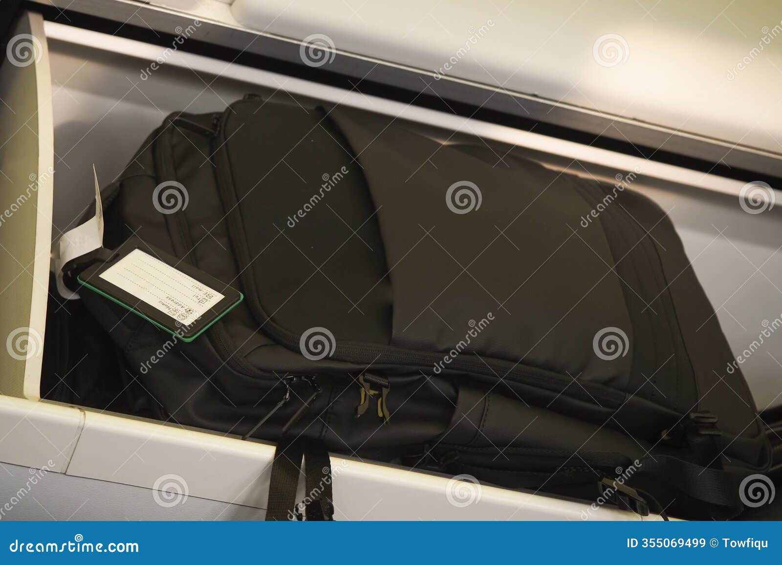A Black Backpack Has Been Conveniently Stored in the Overhead Cabin ...