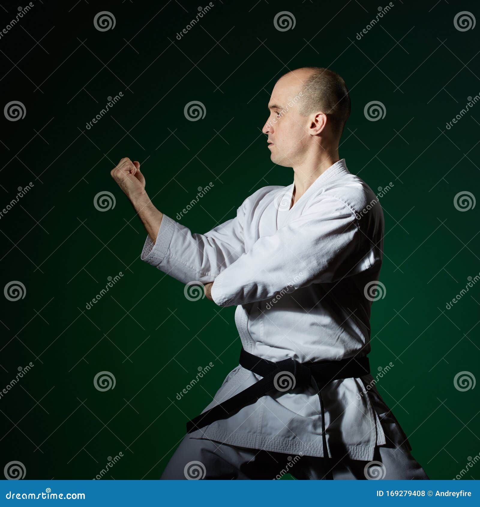 With a Black Belt, the Athlete Does Formal Karate Exercises on a Dark ...