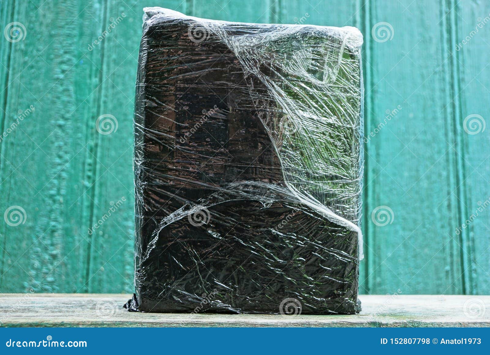 A Black Box in a Gray Cellophane Package Stands on a Table Stock Photo ...