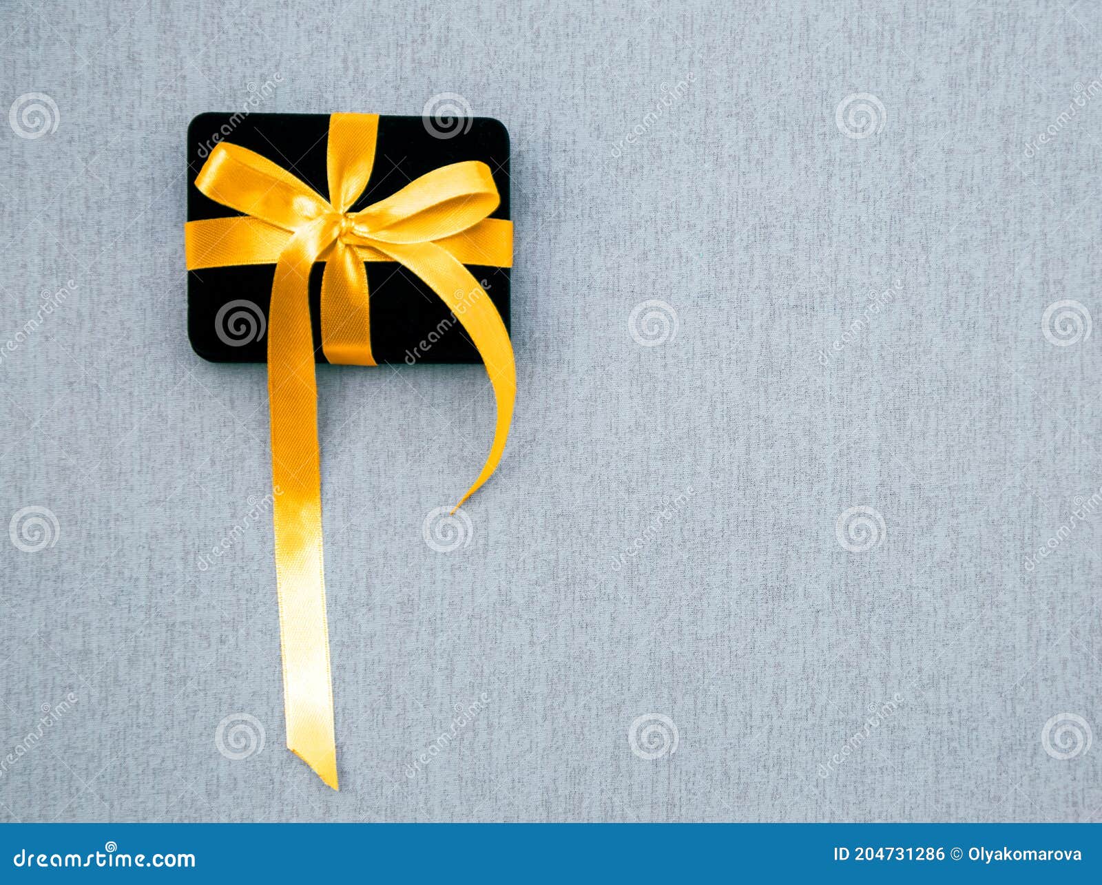 Black Box with Yellow Ribbon on a Gray Background. Copy Space Stock ...
