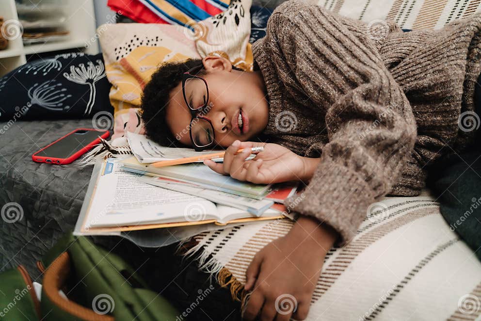 Black Boy Sleeping while Doing Homework on Sofa at Home Stock Photo ...
