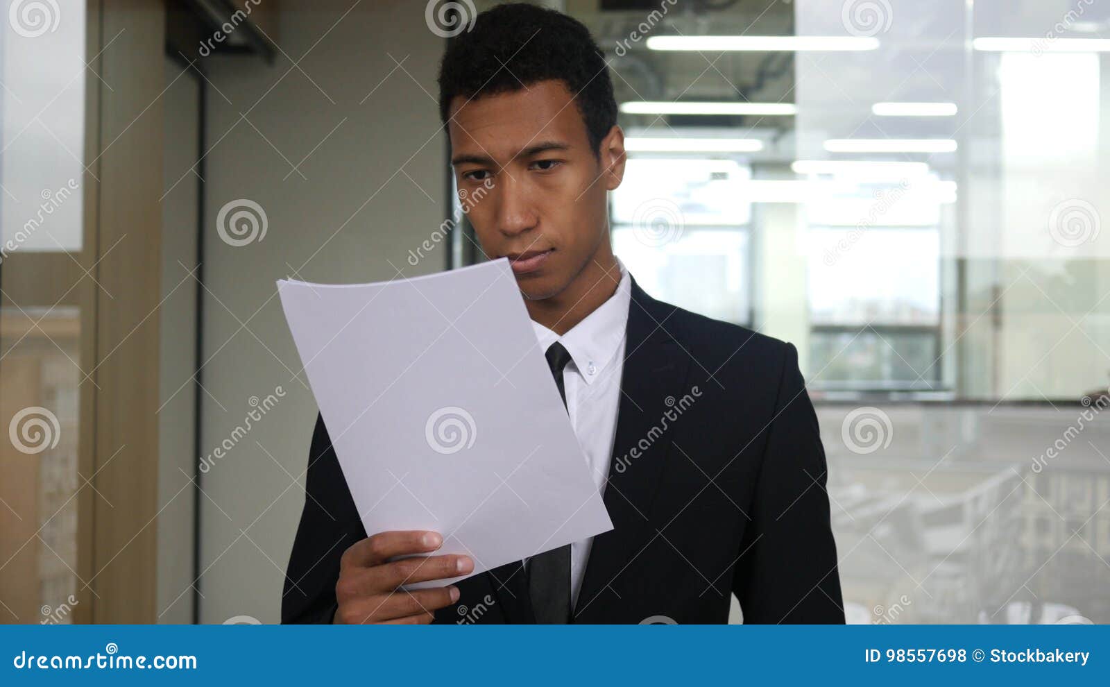 Black Businessman Reading Documents in Office Stock Photo - Image of ...
