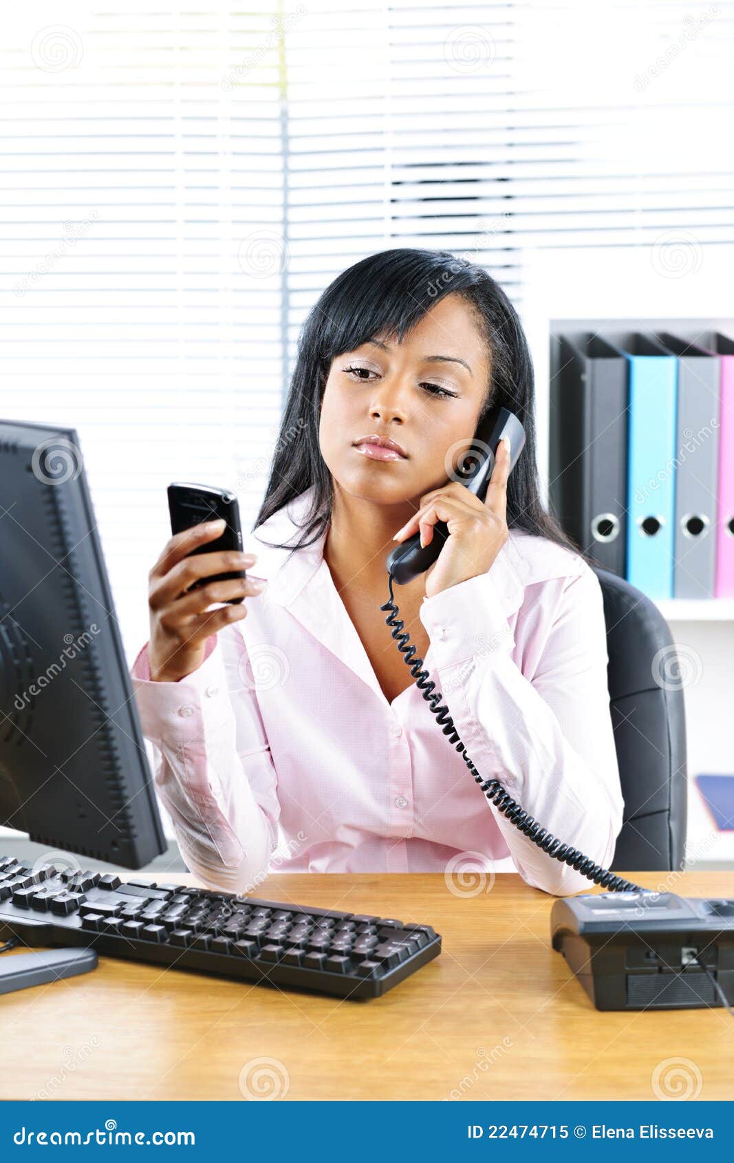 Black Businesswoman Using Two Phones at Desk Stock Image - Image of ...