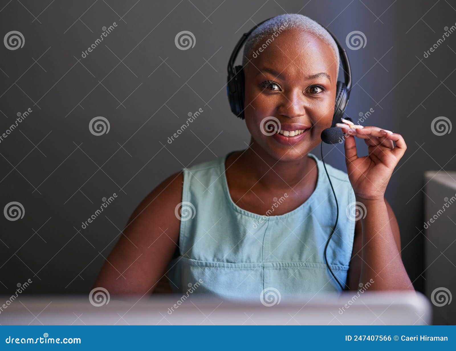 A Black Call Centre Agent Smiles while on a Call with Headset Stock ...