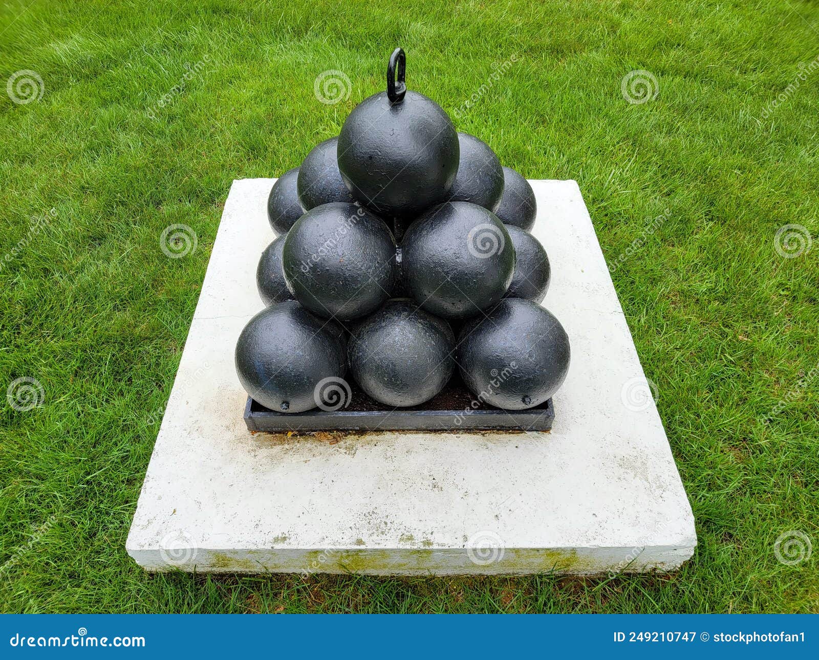 Black Cannonballs in Pyramid Stack on Cement on Grass Stock Image ...