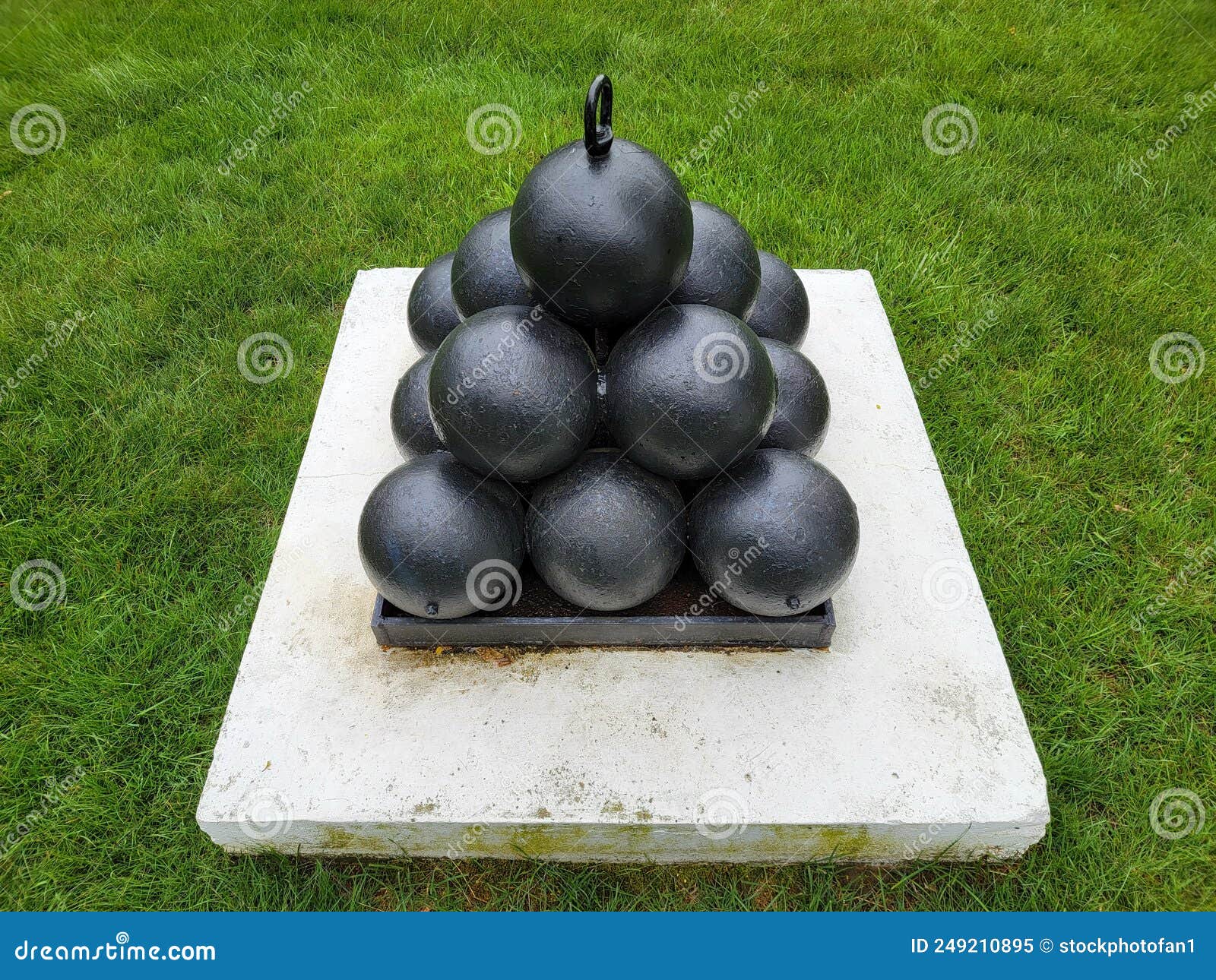 Black Cannonballs in Pyramid Stack on Cement on Grass Stock Image ...