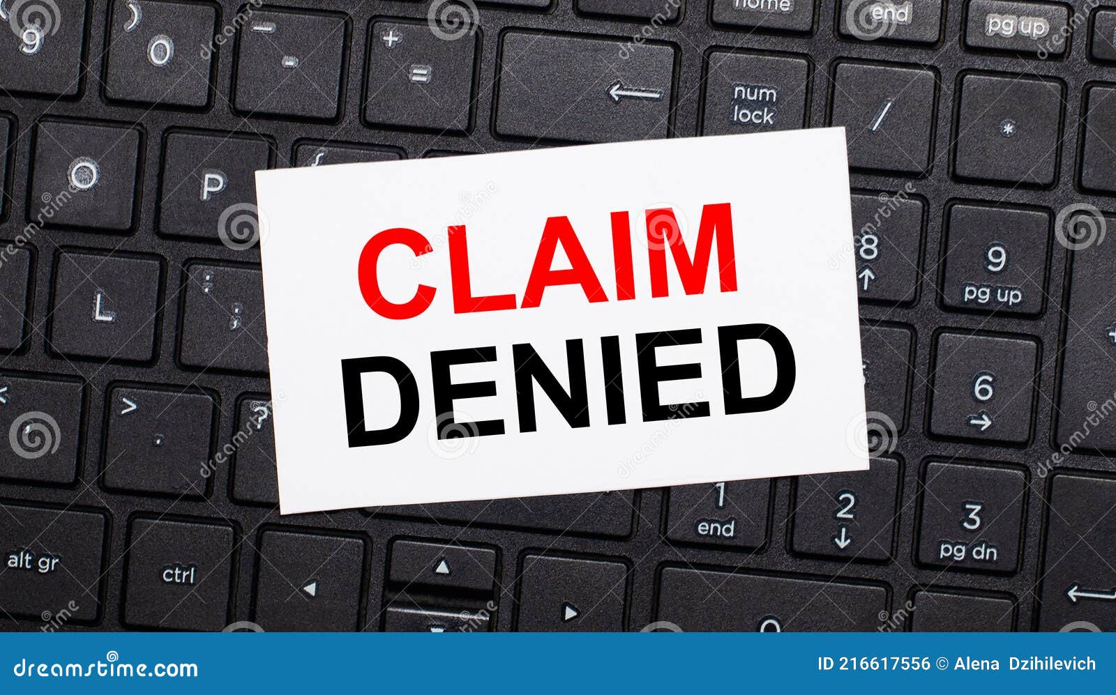 On a Black Computer Keyboard There is a White Card with the Text CLAIM ...