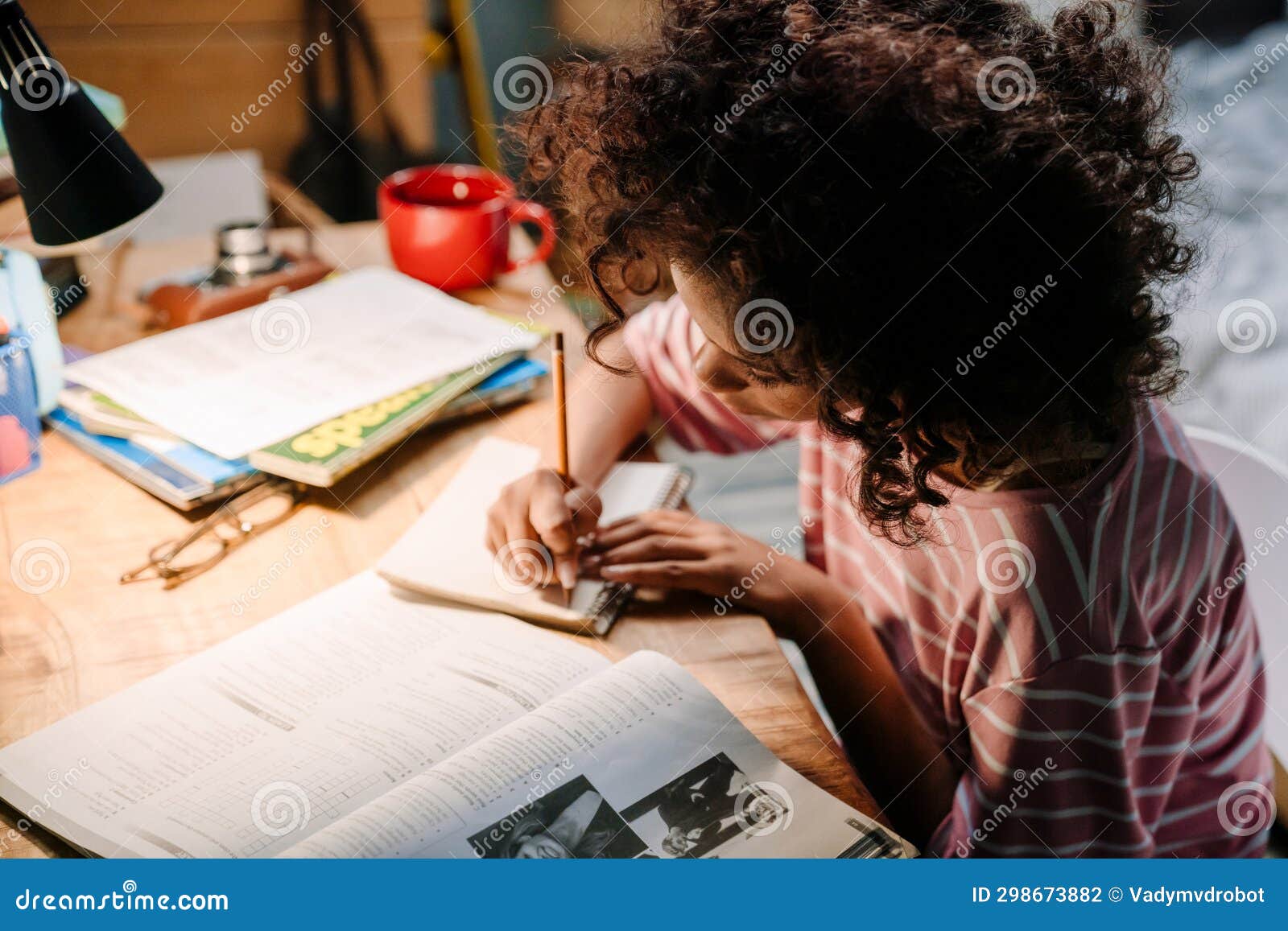 Black Curly Girl Doing Homework while Sitting at Table Stock Photo ...