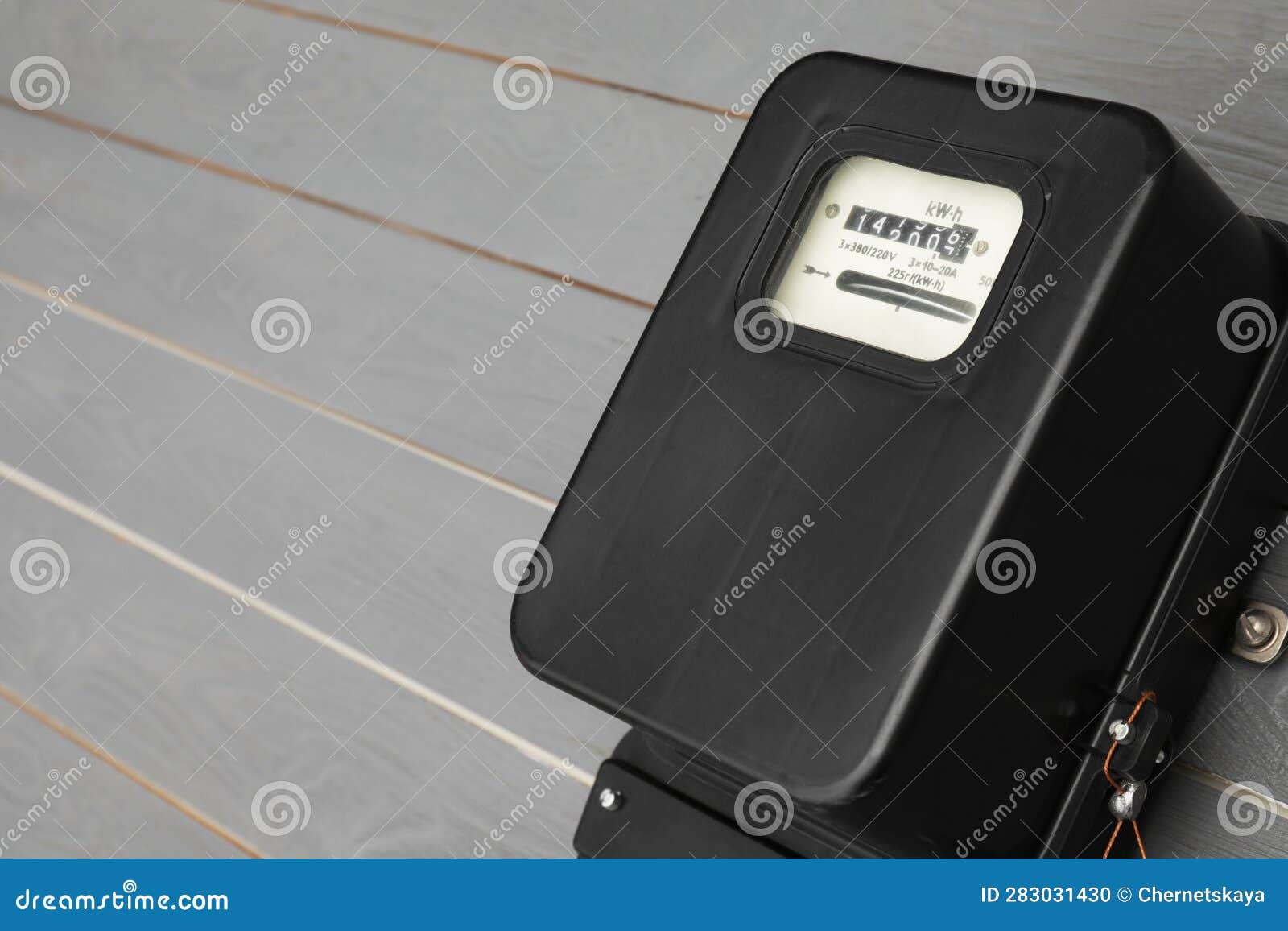 Black Electric Meter on Grey Wooden Wall, Space for Text. Measuring ...