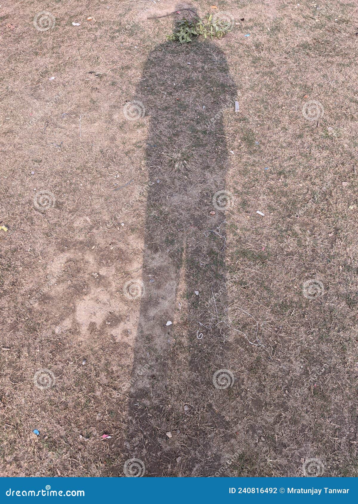 Tall Shadow Of A Tower Extending Over Dry Ground At Sunset Near A ...