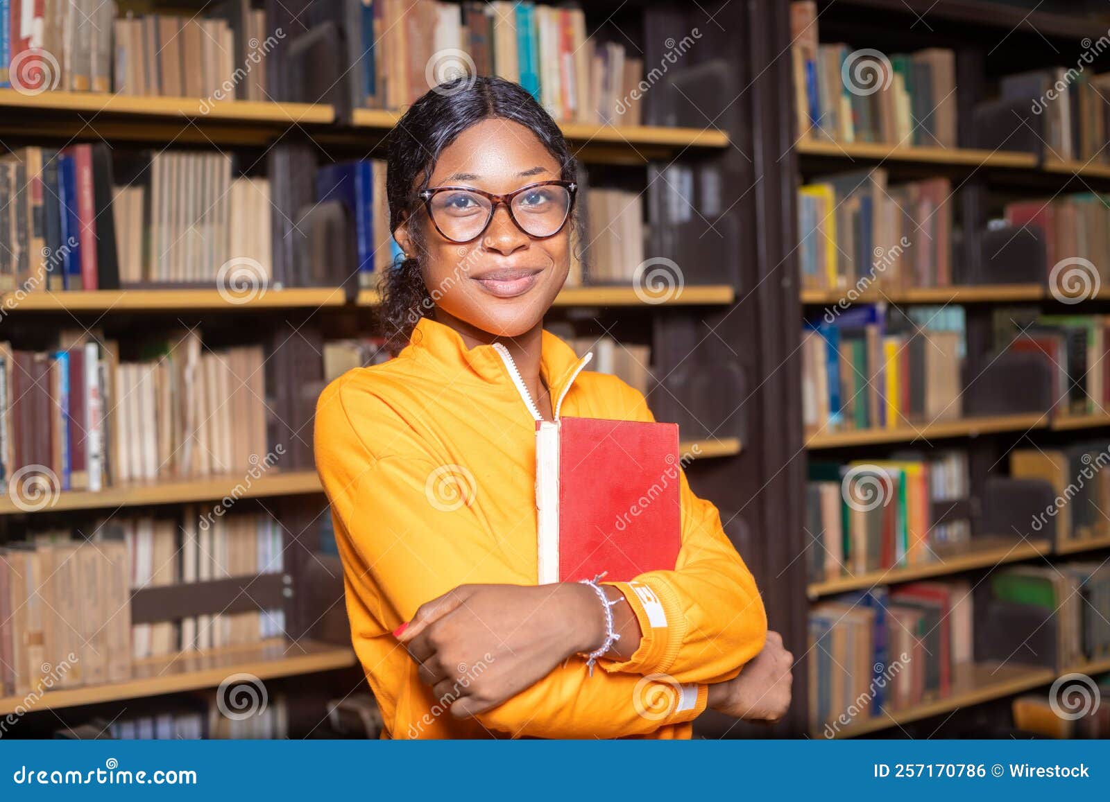 Black Female Student Holding a Red Book and Standing in the College ...