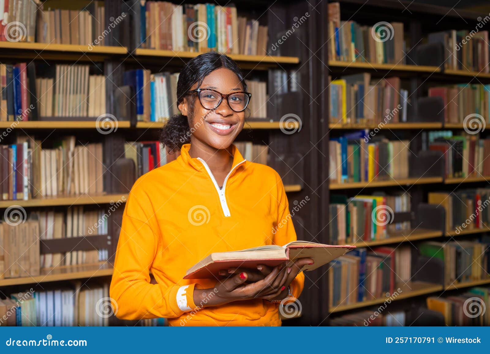 Black Female Student Holding a Red Book and Standing in the College ...