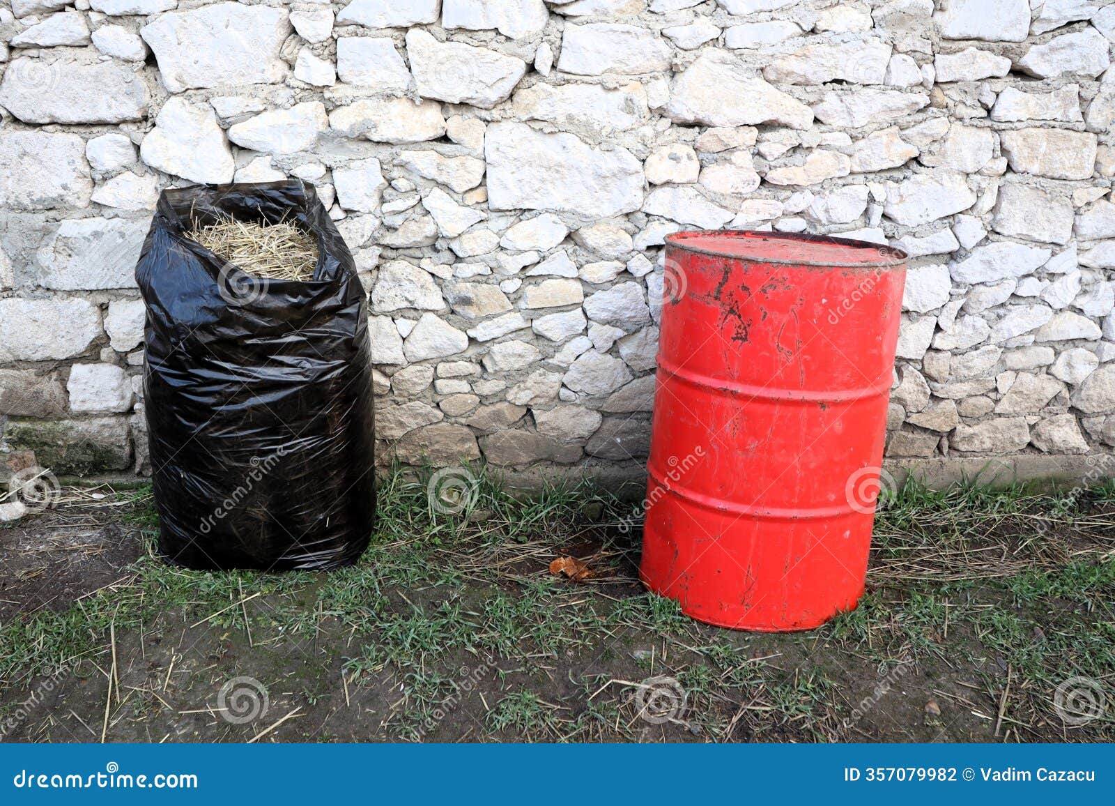 The Waste Disposal Setup Includes a Black Bag and a Red Barrel Placed ...