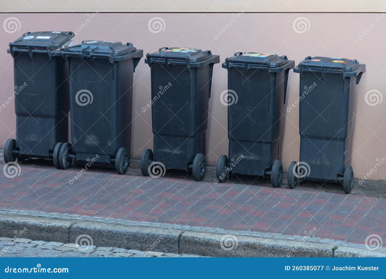 Black Garbage Cans Standing in a Row on a Sidewalk Stock Image - Image ...
