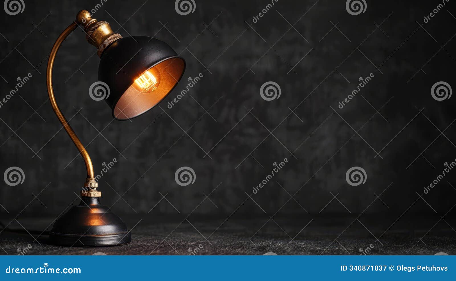 A Black and Gold Desk Lamp with a Dim Side Light Against a Dark ...